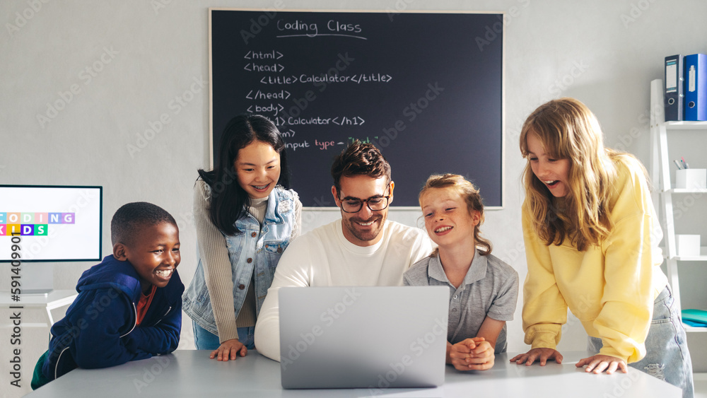 Coding school teacher showing a group of curious children how to write ...
