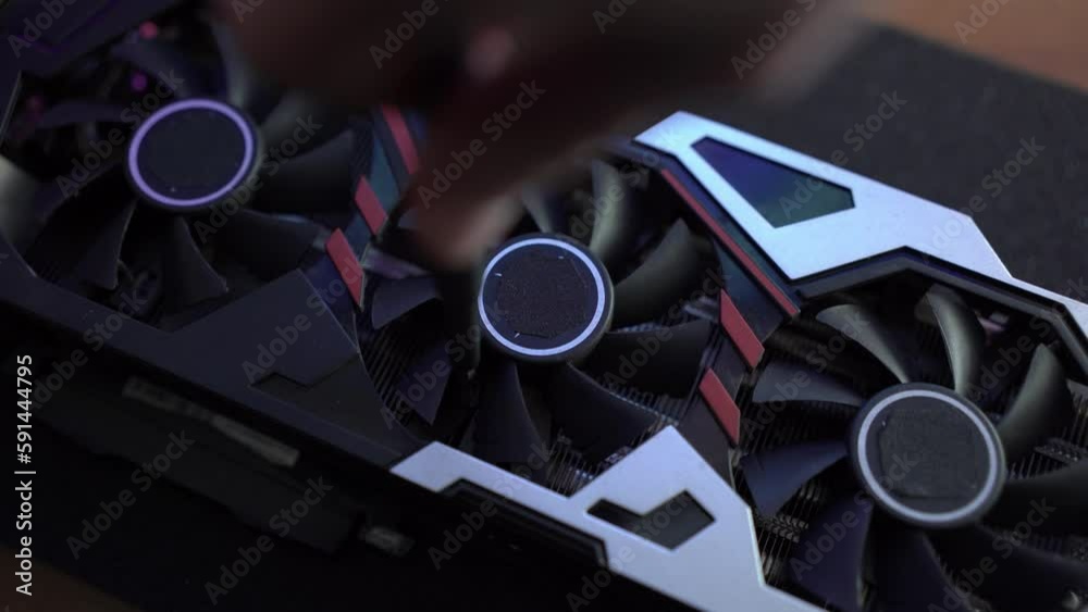 A computer technician takes apart a dirty video card to remove dust ...