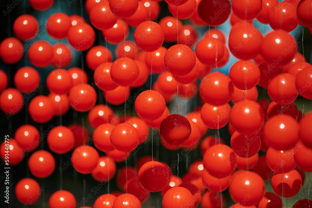 Red balls suspended on wire, outdoor art object symbolizing blood cells ...