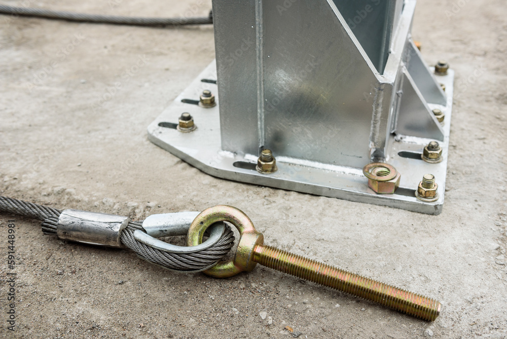 Installation of support with cables in crash barriers on highway. Bolts ...