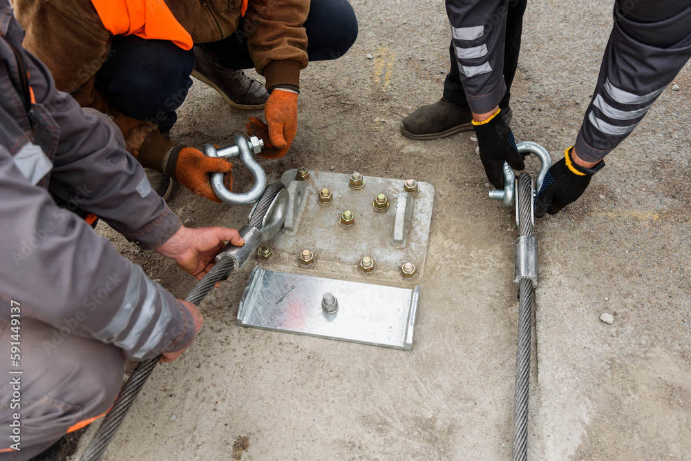 Cable tensioning. Installation of support in crash barriers on highway ...