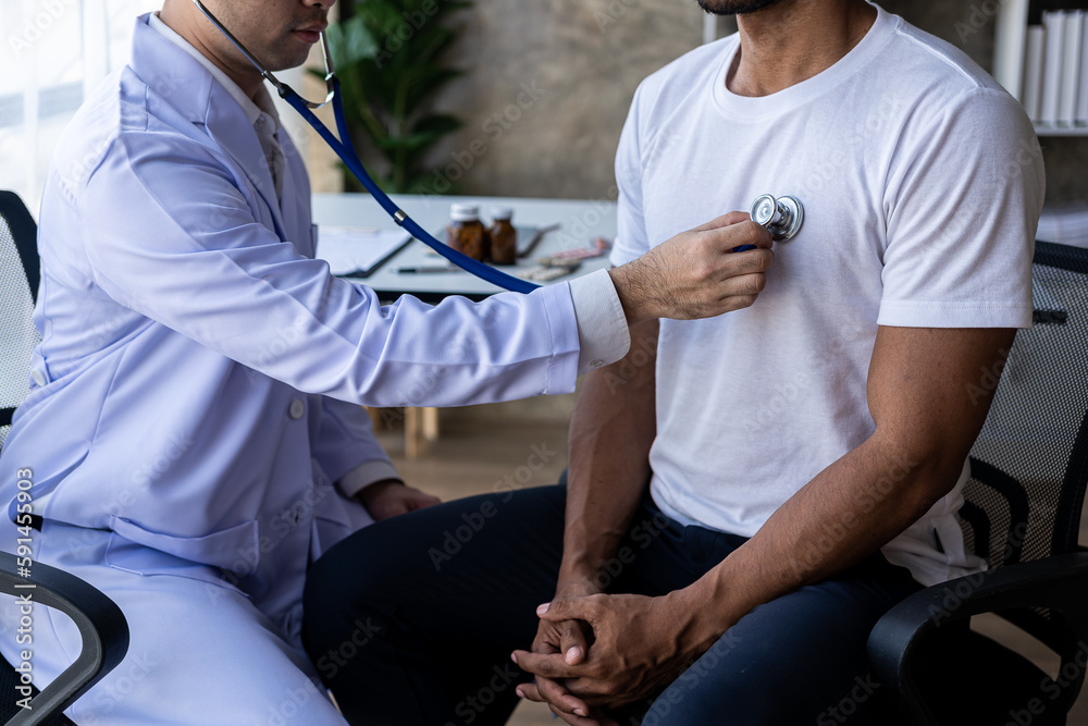 Male doctor caring for patient holding stethoscope listening to patient ...