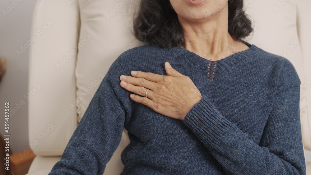 Asian mature woman feeling Heart attack, panic attack, sitting on sofa ...