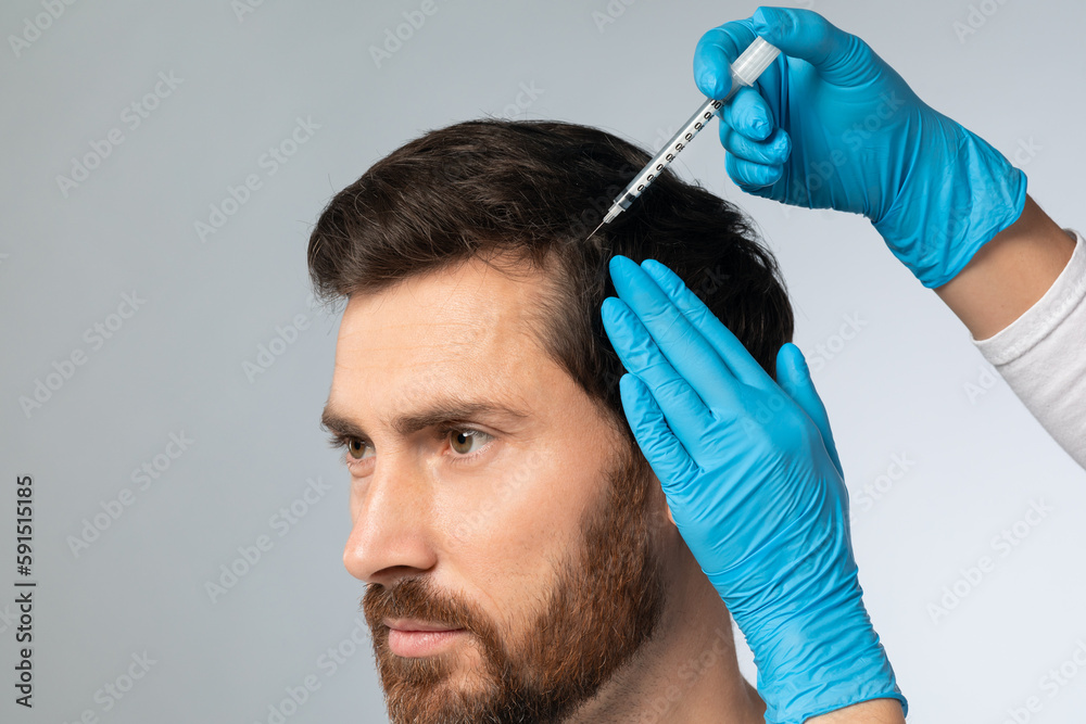 Mesotherapy for male hair. Handsome man receiving injections in his ...