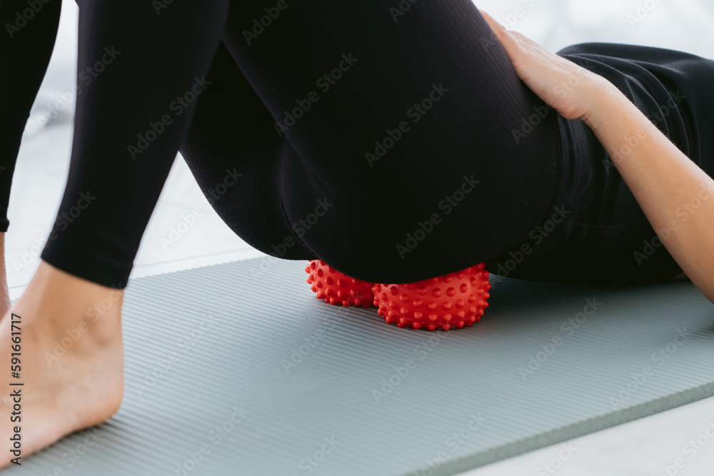 Woman lying on small balls to eliminate back pain, massage stiff ...