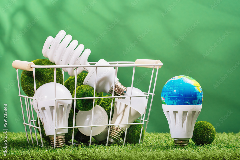 Earth Day. Earth globe and led bulbs in basket in green background ...