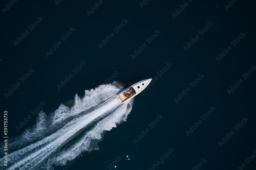 Large high speed white boat with orange chairs and people fast moving ...