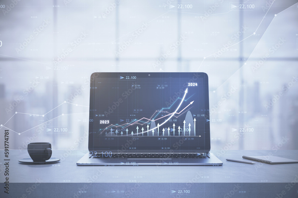 Close up of laptop on desktop with coffee cup, growing business chart ...