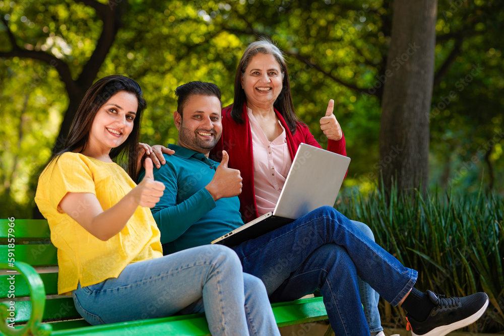 Indian people using laptop and showing thumps up at park Stock Photo ...