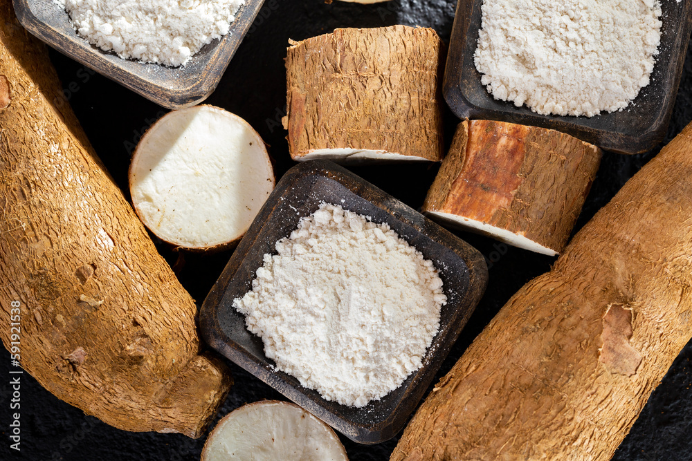 Poster pile of cassava and cassava flour on dark background (Manihot ...