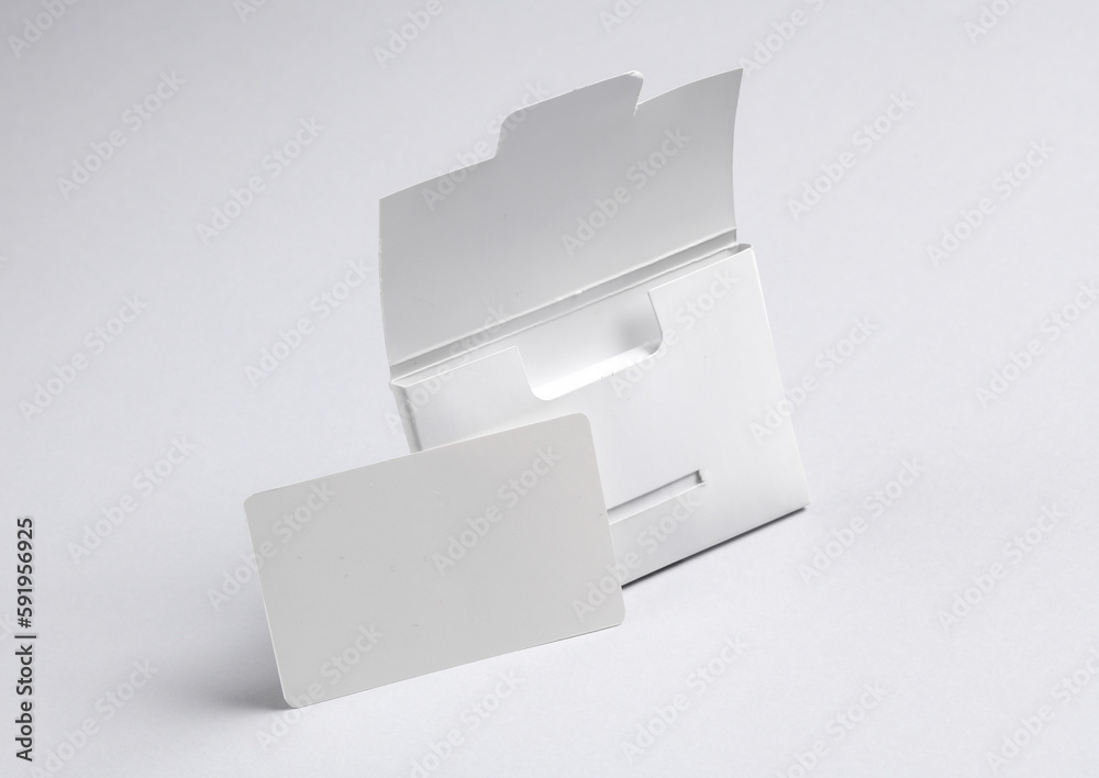 Packing box with empty white bank card on a gray background. Template ...