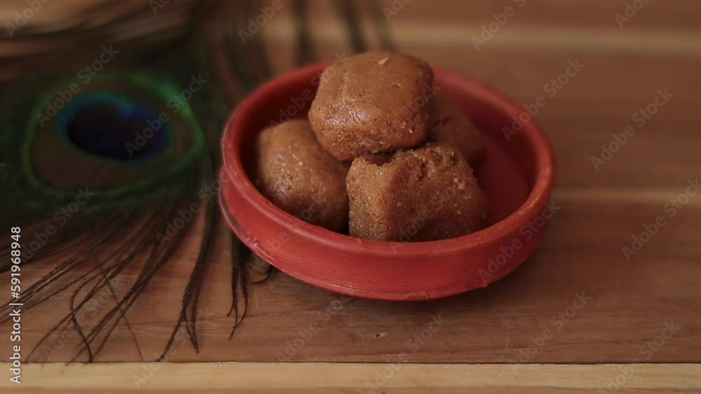 Mathura ka peda is served on a clay plate with peacock feather during ...