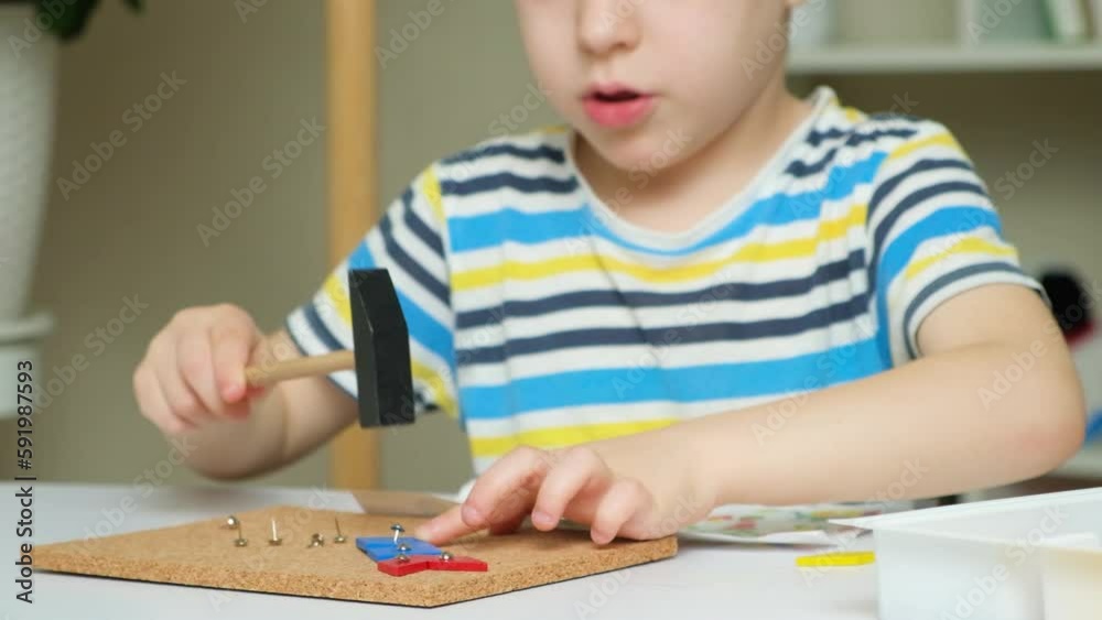 A preschool child plays with a mosaic, builds figures on a board ...