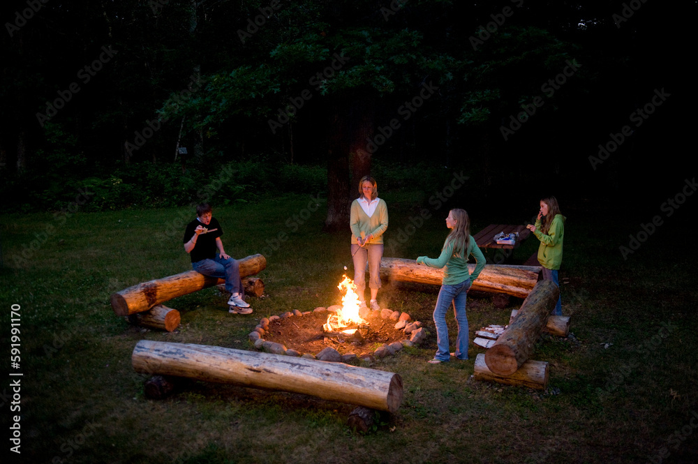Family enjoying s'mores around a campfire; Cross Lake, Minnesota ...