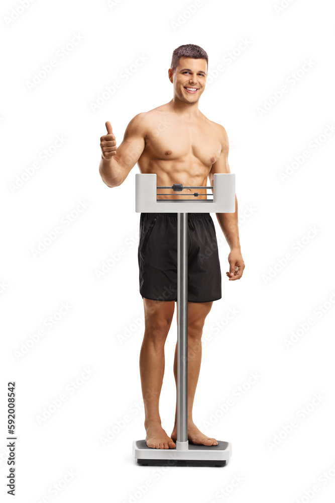 Full length shot of a shirtless young fit man standing on a weight ...