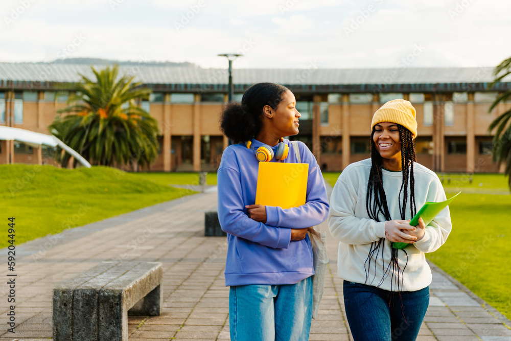 group of multiracial female friends leaving class on the university ...