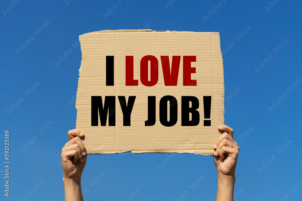 I love my job text on box paper held by 2 hands with isolated blue sky ...