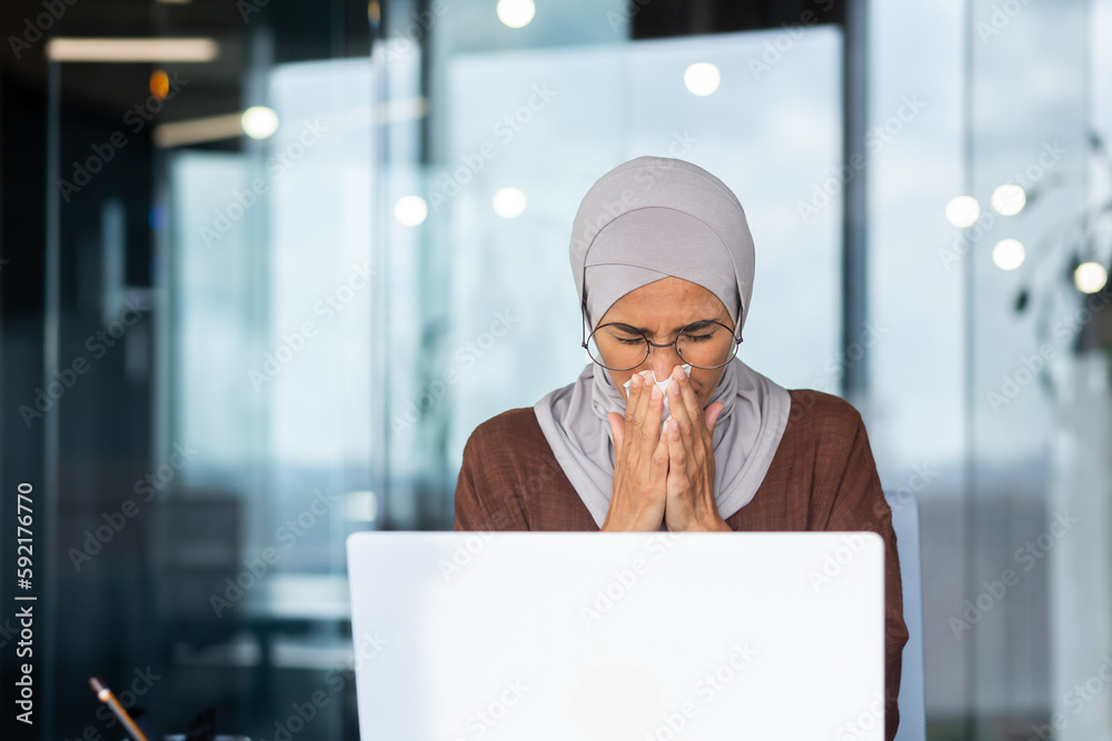 Businesswoman sick at workplace, Muslim woman in hijab sneezing and ...