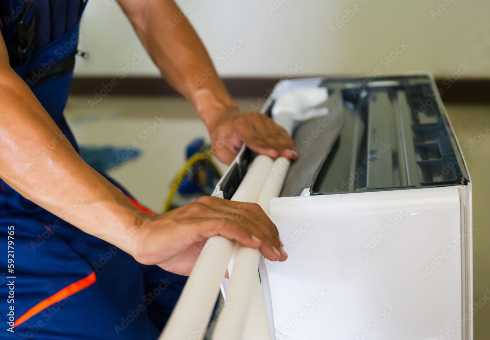 Technician man installing an air conditioning in a client house, Young ...