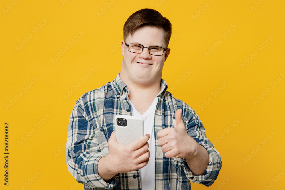 Young happy man with down syndrome wears glasses casual clothes hold in ...