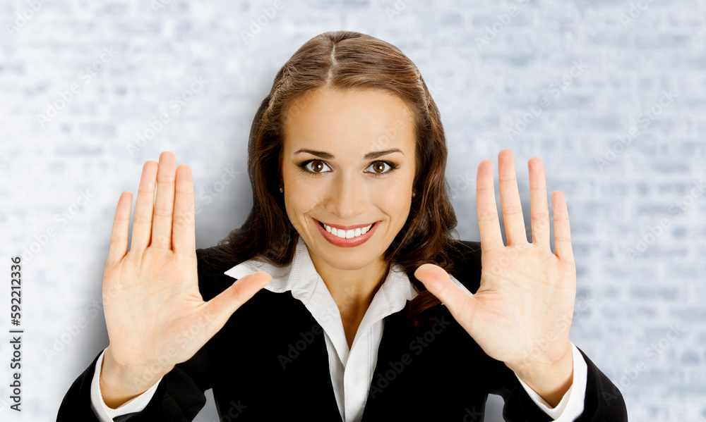 Smiling business woman in black suit showing stop gesture, on white ...