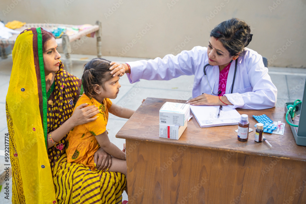 Indian female doctor checking little child patient at village. Stock ...