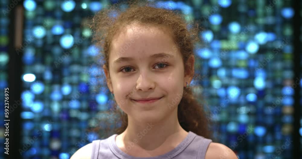 Portrait happy little girl standing on a background of blue glossy ...