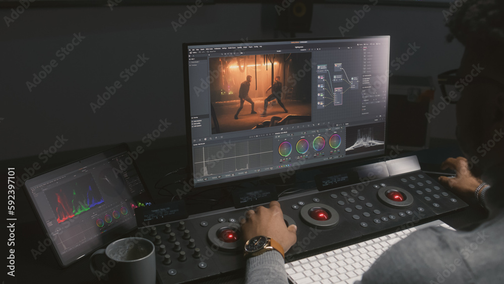 African American colorist makes color grading on control machine in ...