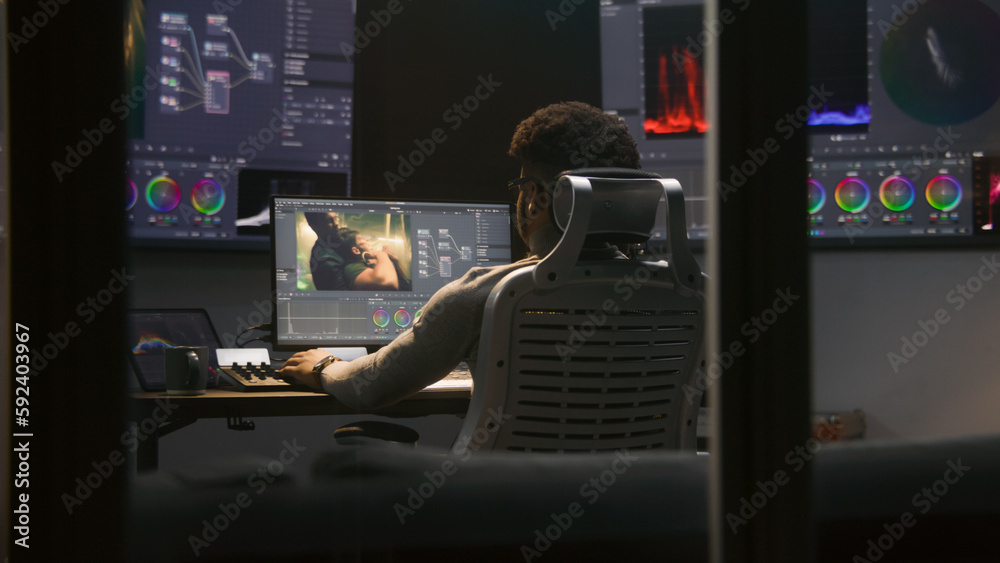 Experienced African American video maker does color grading in program ...