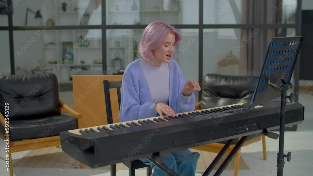 Positive talented beautiful pink haired female musician playing ...