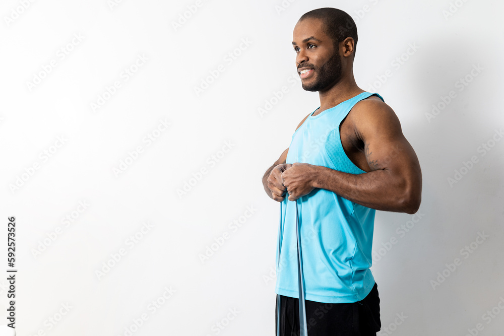 Dark-skinned muscular man poses on a white background in sportswear ...