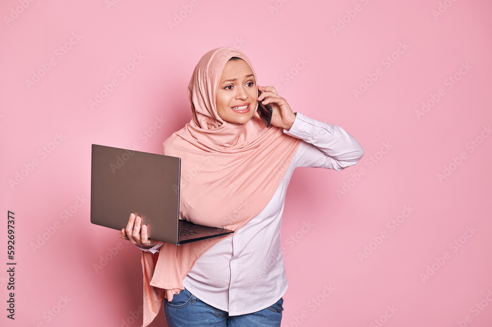 Multitasking overworked busy pregnant Arab business woman in pink hijab ...