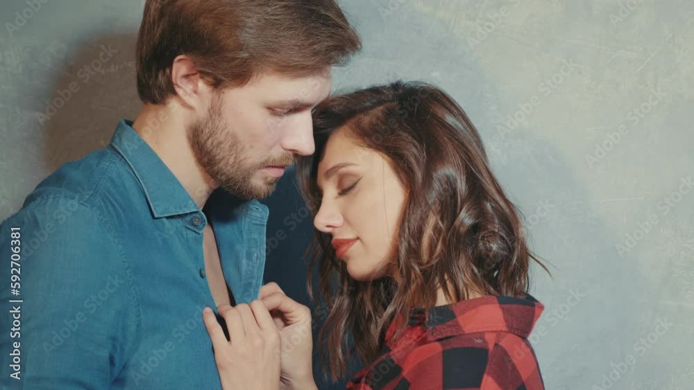 Hot beautiful woman and her handsome boyfriend. Models posing near grey ...