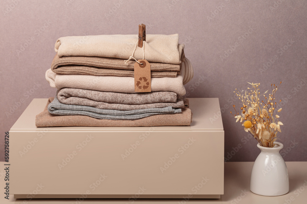 Stack of clothes with used wardrobe and tag with circular economy logo ...