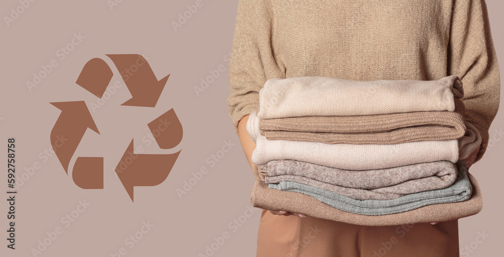 Woman holding stack of clothes with used wardrobe for reuse and ...