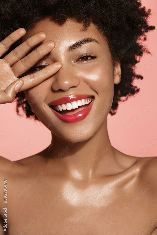 Vertical shot of gorgeous Black woman with healthy smile, touches her ...