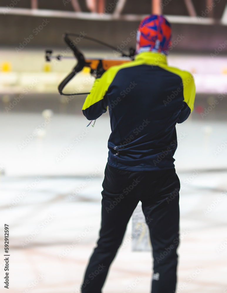 Biathlete with rifle on a shooting range during biathlon training ...