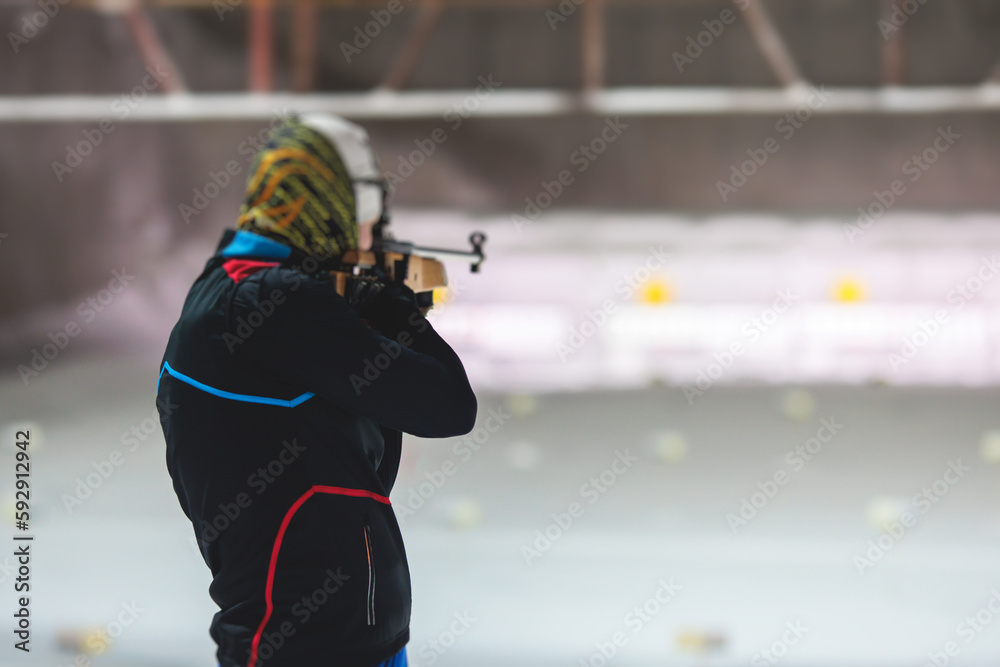 Biathlete with rifle on a shooting range during biathlon training ...
