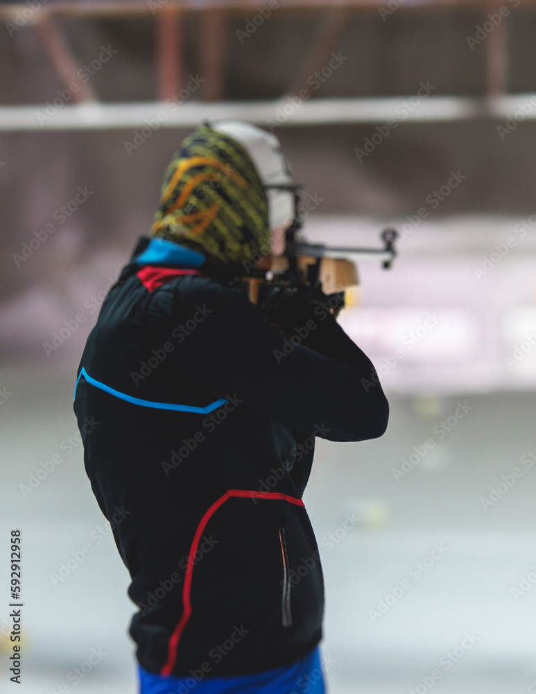 Biathlete with rifle on a shooting range during biathlon training ...