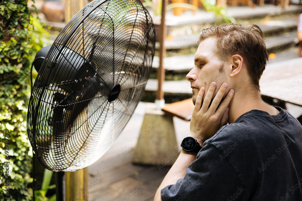 Heat wave during a summer, a man finds respite at his home balcony with ...