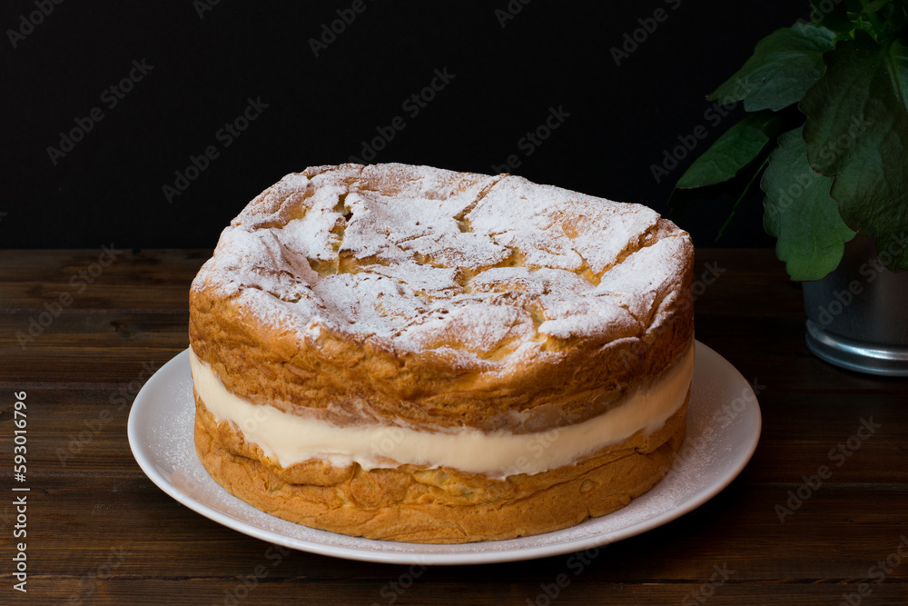 Foto de Tarta polaca de pasta choux rellena de crema con azúcar glas ...