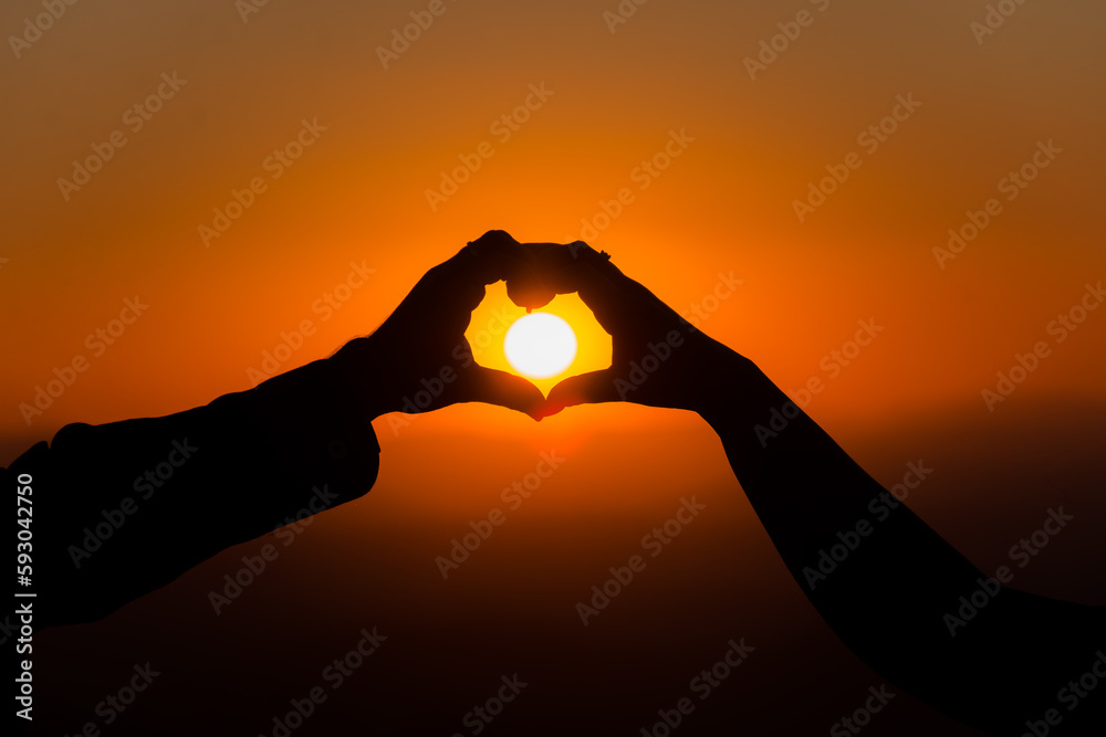 O sol dentro de um coração feito por mãos Stock Photo | Adobe Stock