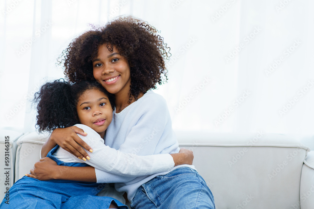 Foto de Happy cheerful little American - African ethnicity little girl and mother staying ...