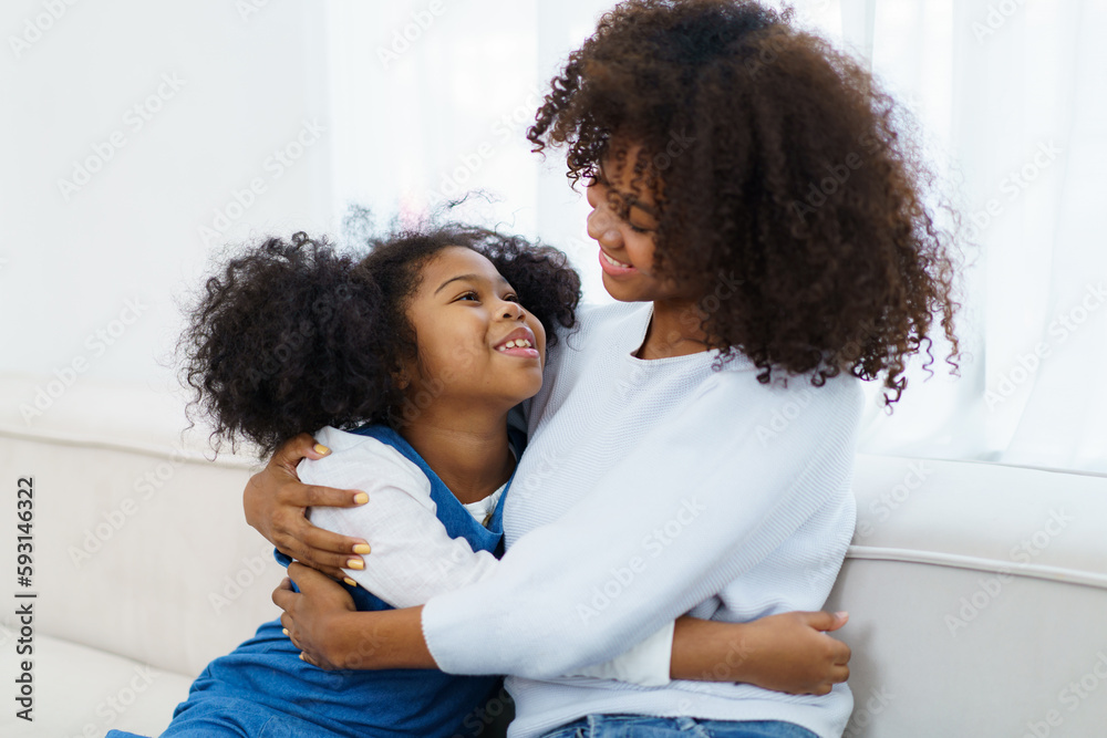 Foto de Happy cheerful little American - African ethnicity little girl and mother staying ...