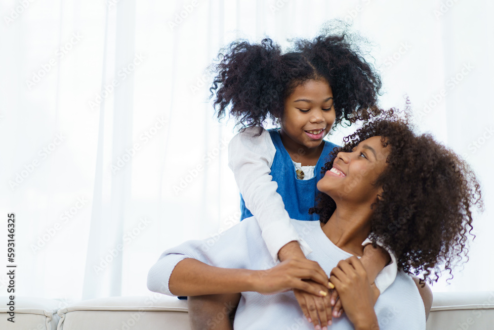 Happy cheerful little American - African ethnicity little girl and mother staying together, mom ...