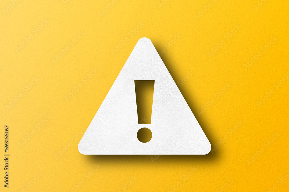 White paper punched into the shape of an exclamation mark. warning sign ...