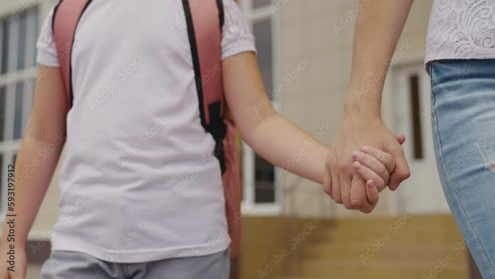 mother holds happy daughter by the hand, accompany little child with ...