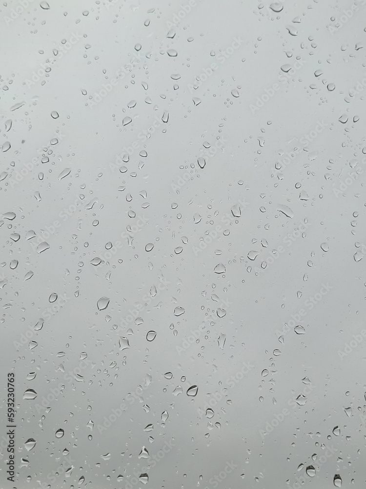 Raindrops on the surface of window panes with gray gloomy cloudy ...