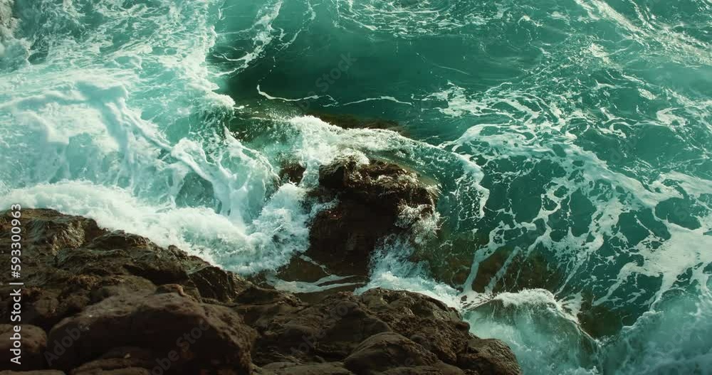 Ocean waves wash over rocky shore. Raging sea turquoise water foaming ...