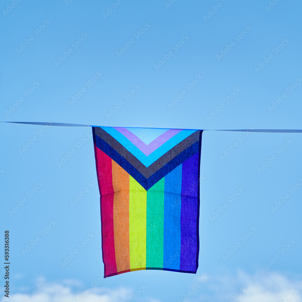 LGBTQ+ flag on blue sky. Progress Pride Flag integrates rainbow lgbt ...